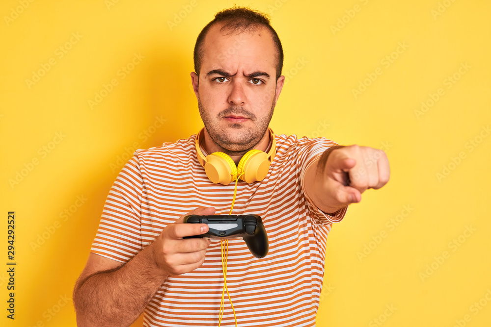 Young gamer man playing video game using headphones over isolated ...