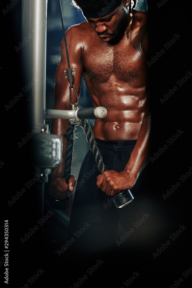 Sweaty shirtless muscular man breathing out when doing triceps ...