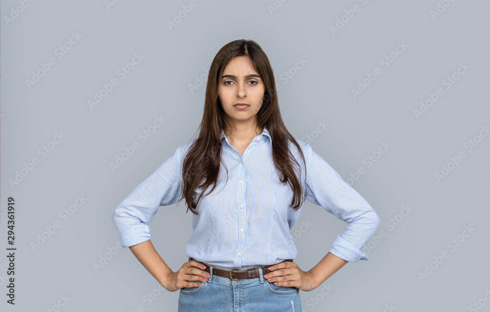 Serious unhappy young adult woman looking at camera and standing ...