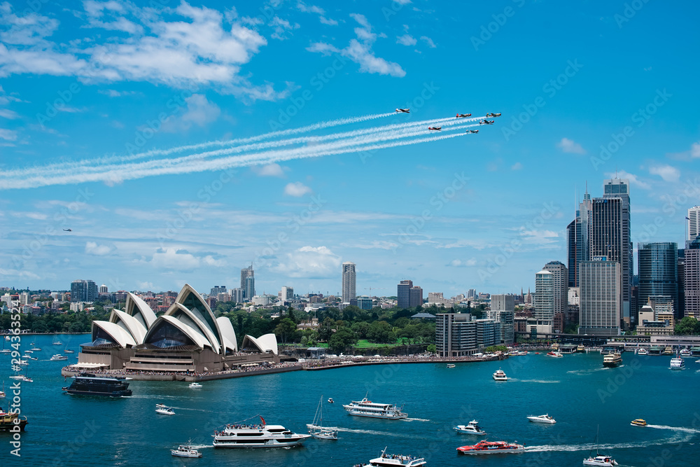 Plakát Planes fly by above the Sydney Skyline with the famous opera ...