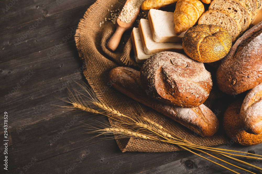Different kinds of bread with nutrition whole grains on wooden ...