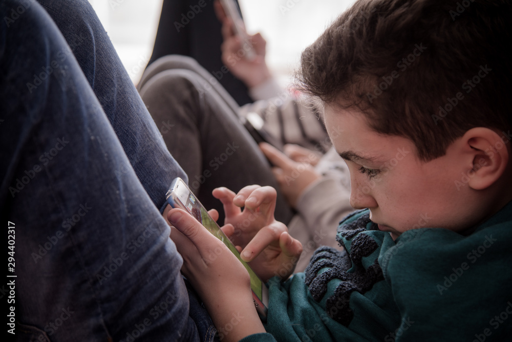 Un jeune garçon regardant un smartphone. Un enfant avec un téléphone ...