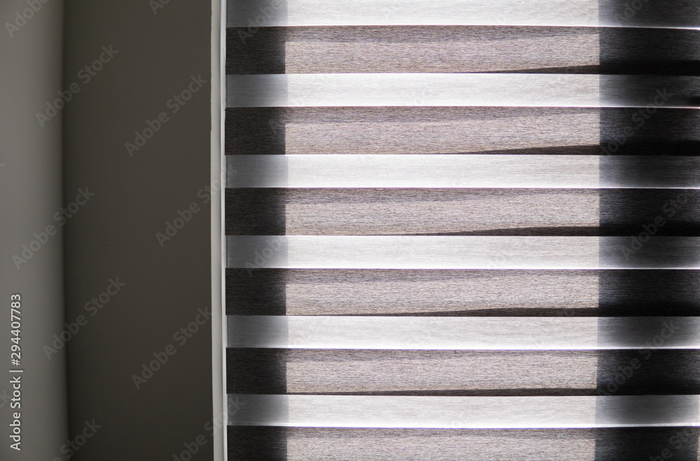 Details of brown fabric roller blinds on the plastic window with wood ...