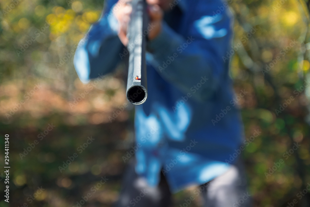 male with a semi-automatic shotgun in the autumn forest aim with a ...