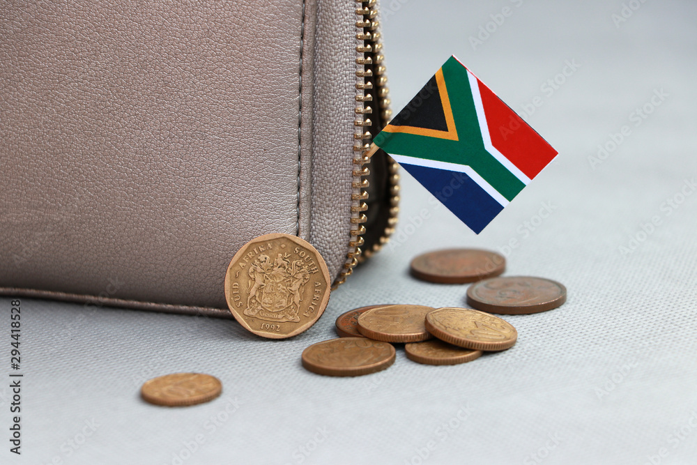 Heap of South African Rand coin money and mini South African flag stick ...
