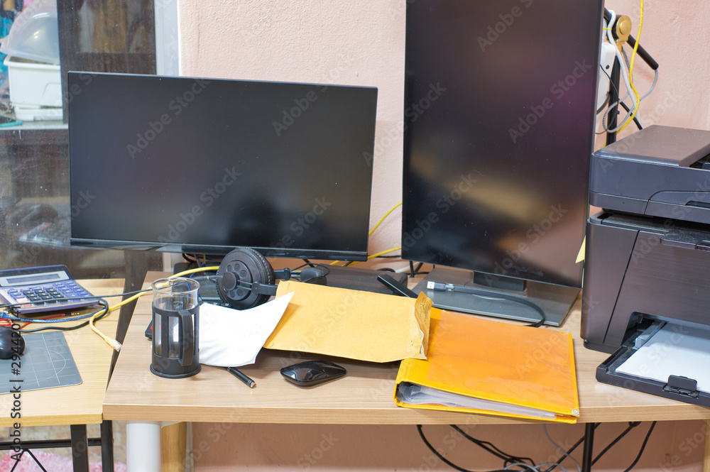 Messy workplace table with PC, monitor and laptop on it. Stock Photo ...