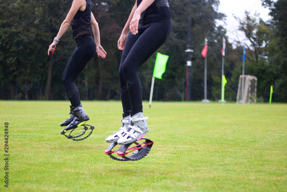 Girls in boots for jumping. Bouncing shoes on the legs of women. Sports ...