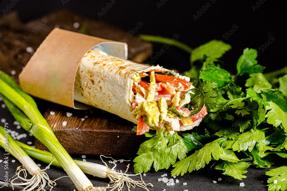 Freshroll shawarma with chicken meat, avocado, standing and lying in a ...
