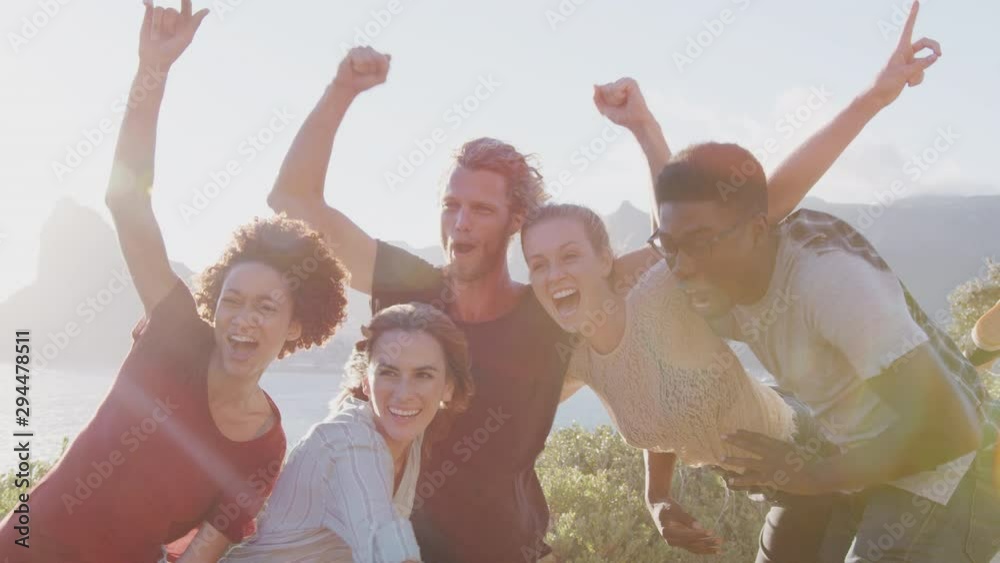 Men Lifting Up Women As Group Of Friends Have Fun Against Flaring Sun ...