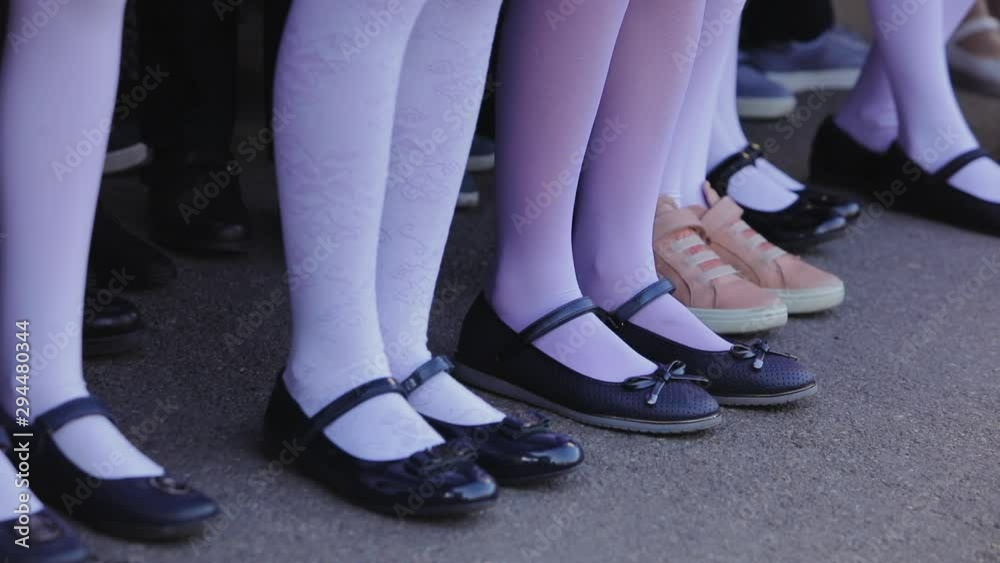 Schoolgirls in white golf, lots of children's feet. First graders on ...