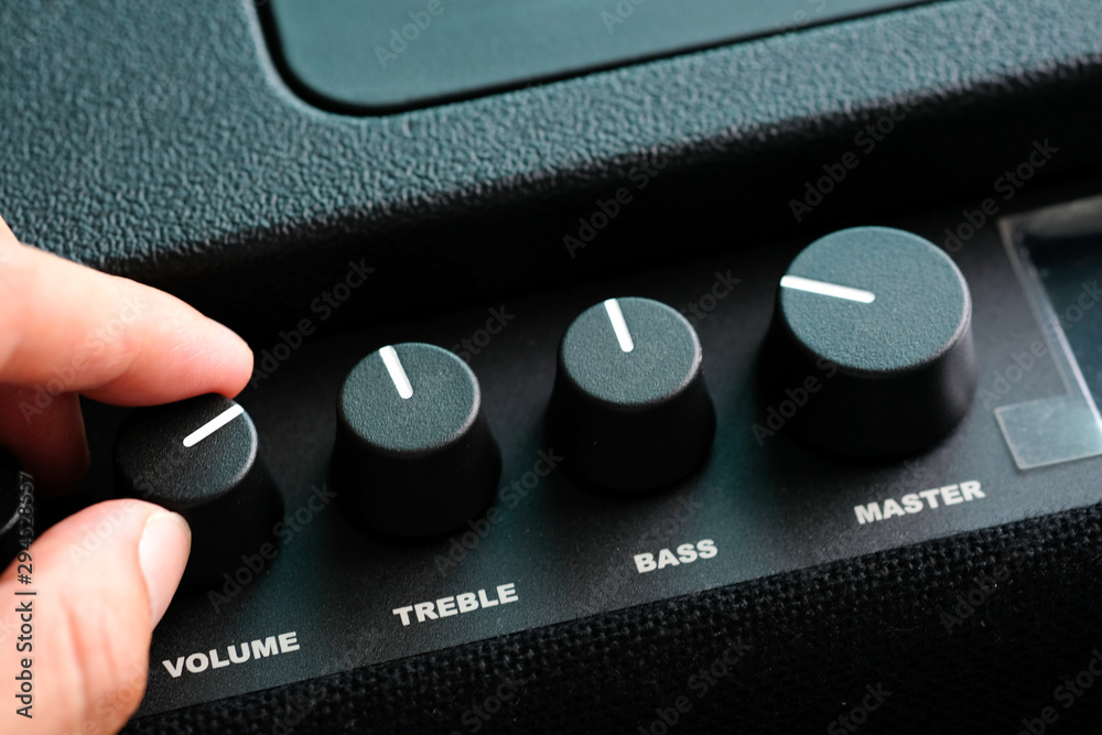 man's hand is adjusting the music volume from the amplifier. Stock ...