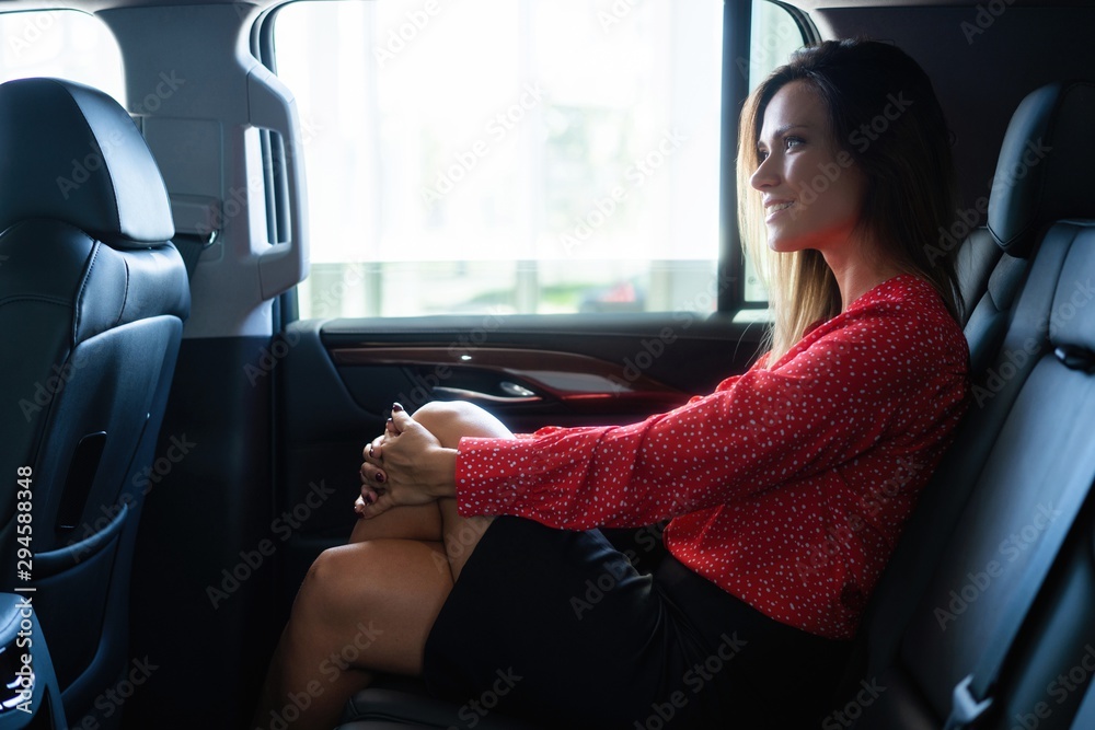 Beautiful businesswoman is sitting on back seat of the car. Stock Photo ...
