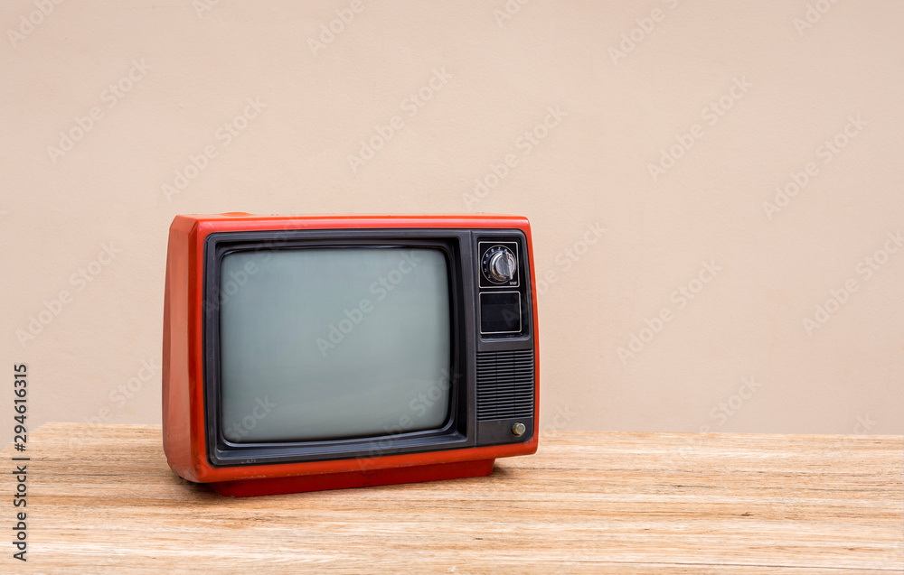 Red old television receiver on wood table with cement wall background ...