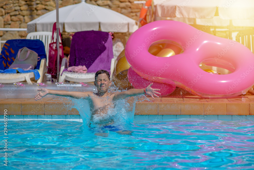 Boy having fun making fantastic jump into swimming pool on summer ...