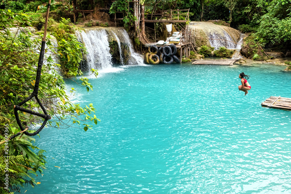 Woman jumping in a waterfall in The Philippines Stock Photo | Adobe Stock