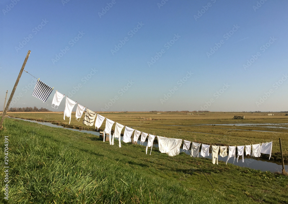 Clothes drying on clothes line over field Stock Photo | Adobe Stock