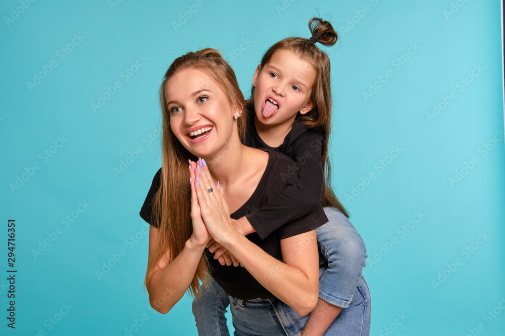 Mom and daughter with a funny hairstyles, dressed in black shirts and ...