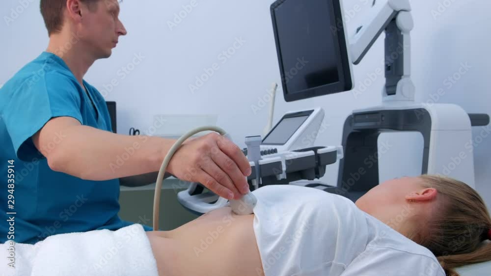 Man doctor making abdominal ultrasound to diagnosis stomach of woman in ...