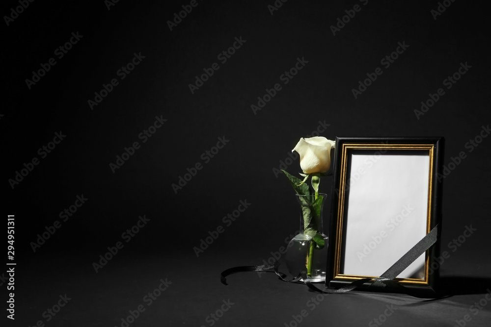 Funeral photo frame with ribbon and white rose on black background ...