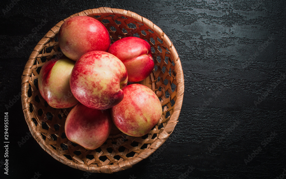 Fresh nectarines in a basket on top.Background of bright and ripe ...