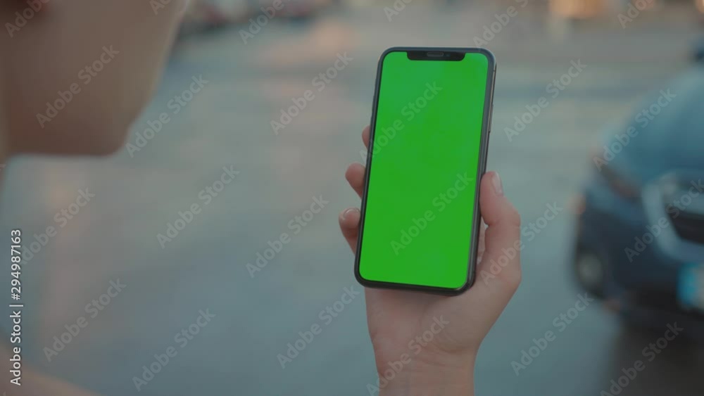 Close-up side view of smart woman holding and using vertical mobile ...