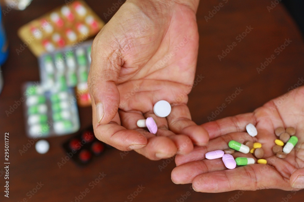 Closeup at elderly Asian man hand is holding many pills(tablet and ...