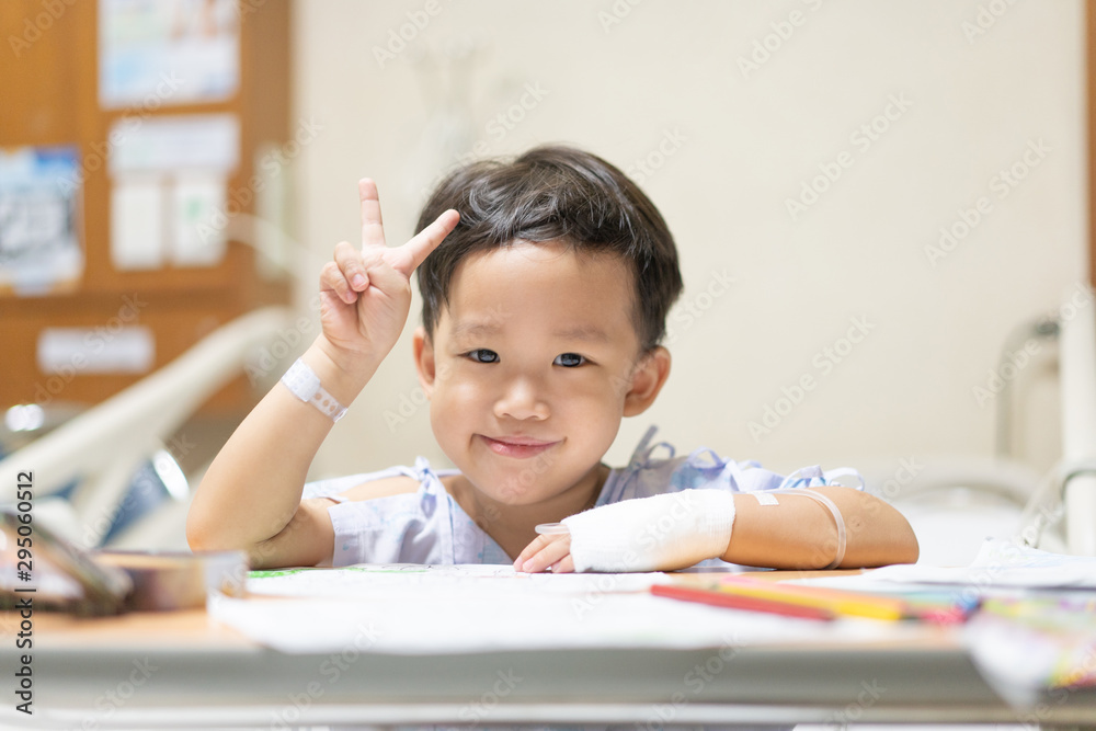 The patient boy is painting the paper with a color pencil in the ...