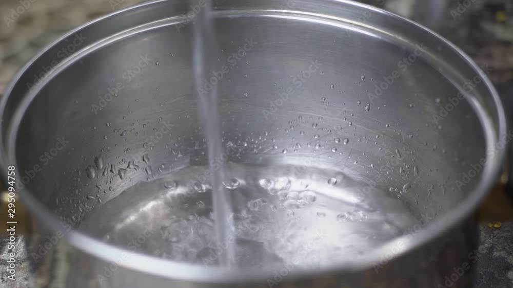 Vidéo Stock Water is poured into the pan in a thin stream, spraying ...