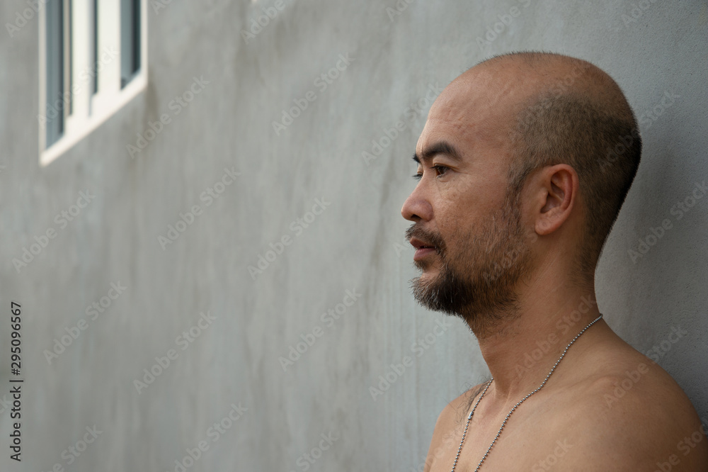 40s of bald beard Japanese man profile portrait on grey cement wall ...