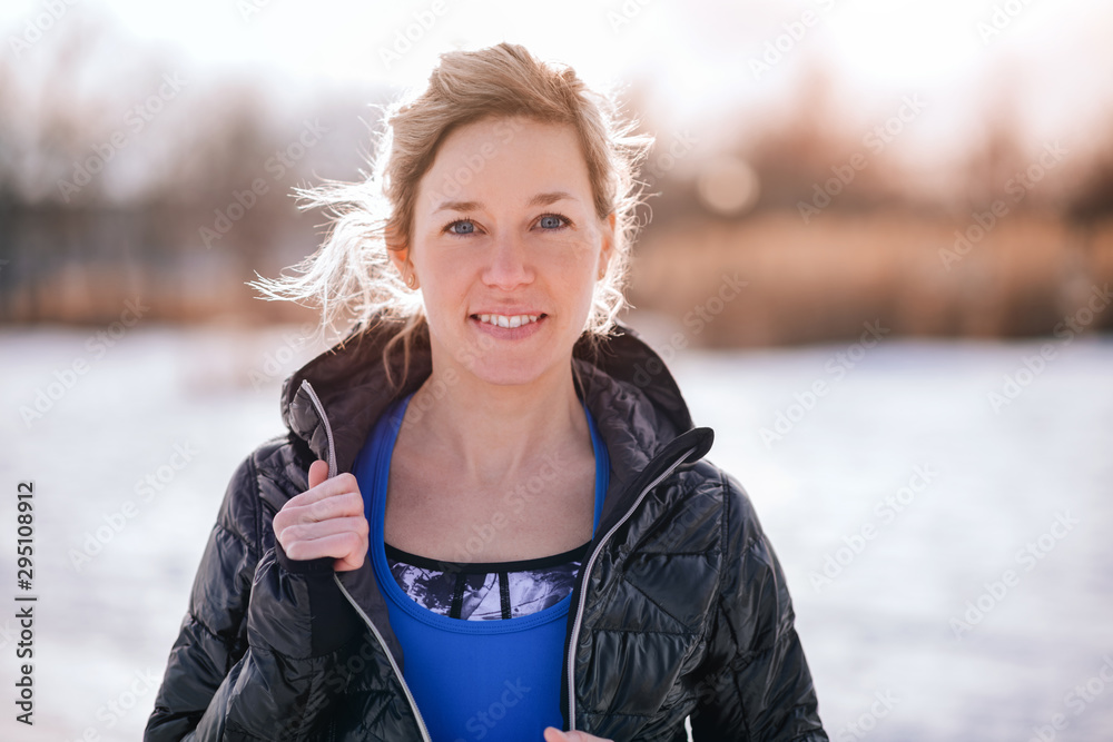 Sporty caucasian woman keeping fit in the winter and going outside in a ...