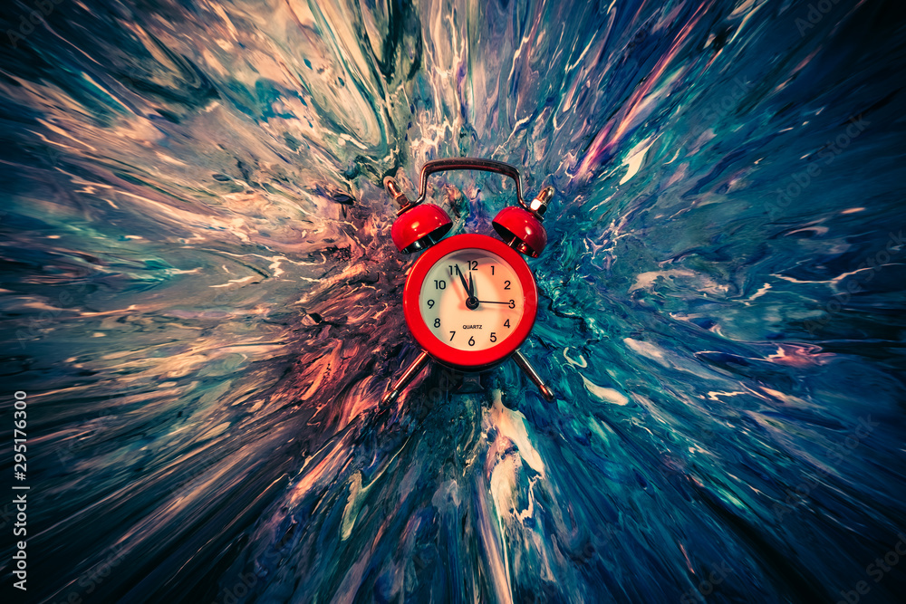 Foto de Time travel concept. Red vintage alarm clock on smeared blue ...