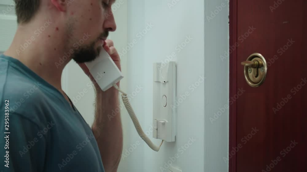 Answering the intercom and pushing the button 4K. Long shot of the ...