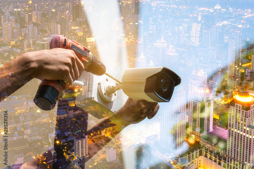 Double exposure technician installation CCTV camera on a pole , show ...