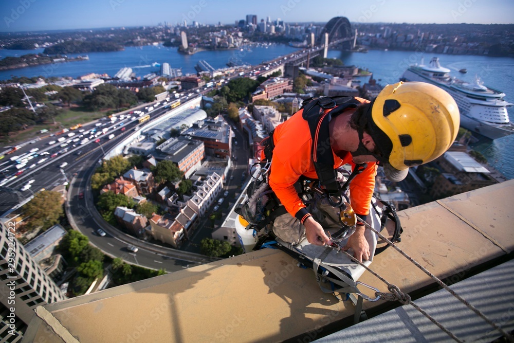 Rope access worker wearing yellow hard hat, long sleeve shirt, Full ...