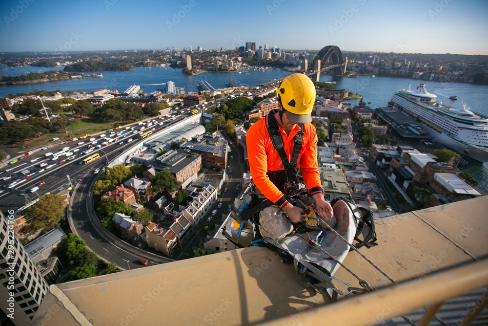 Rope access worker wearing yellow hard hat, long sleeve shirt, Full ...