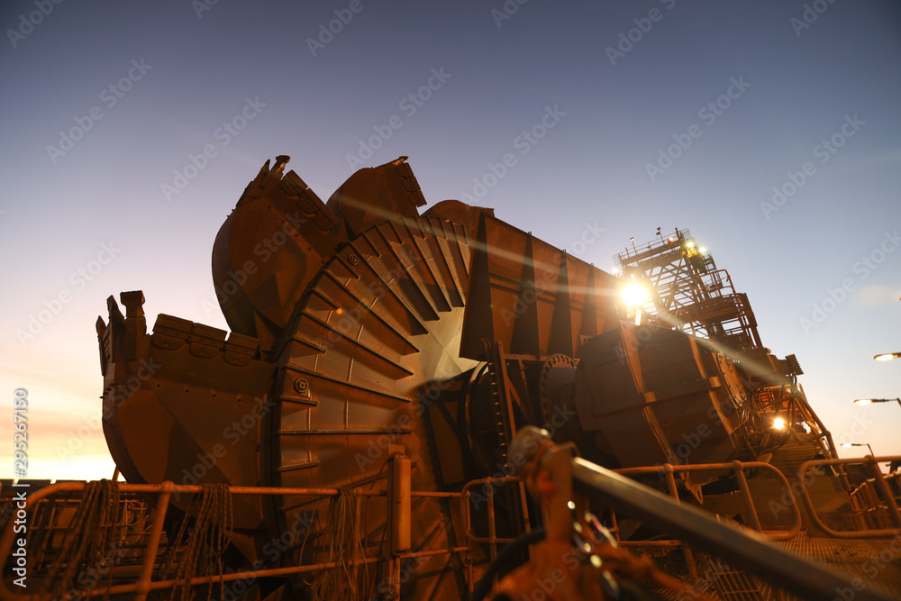 Mining reclaimer wheel bucket heavy machinery early morning sunrise at ...