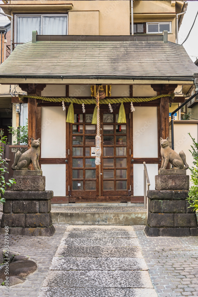 Two statues of foxes inari, deity of rice in the Shinto shrine of ...