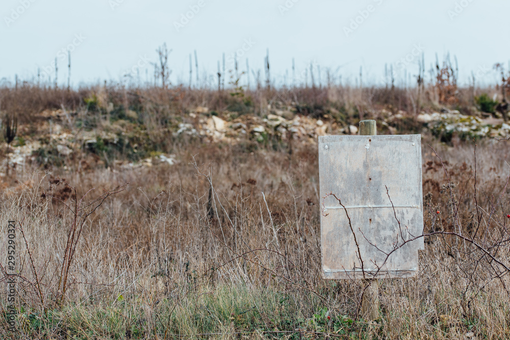 Un terrain vague avec une pancarte. Une friche abandonnée. Une interdiction devant un terrain ...