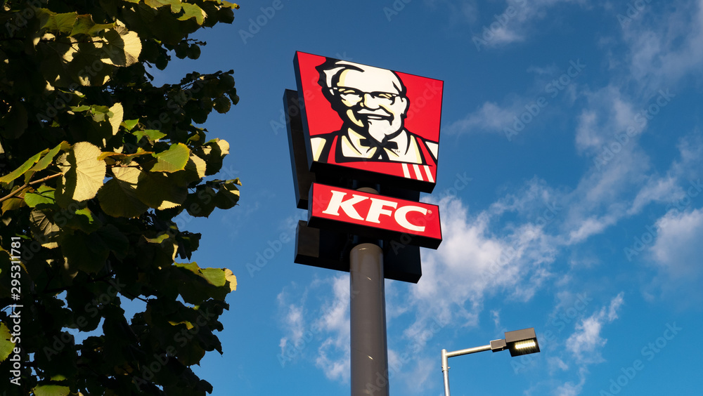 Banner of the KFC fast food chain behind a tree Stock Photo | Adobe Stock