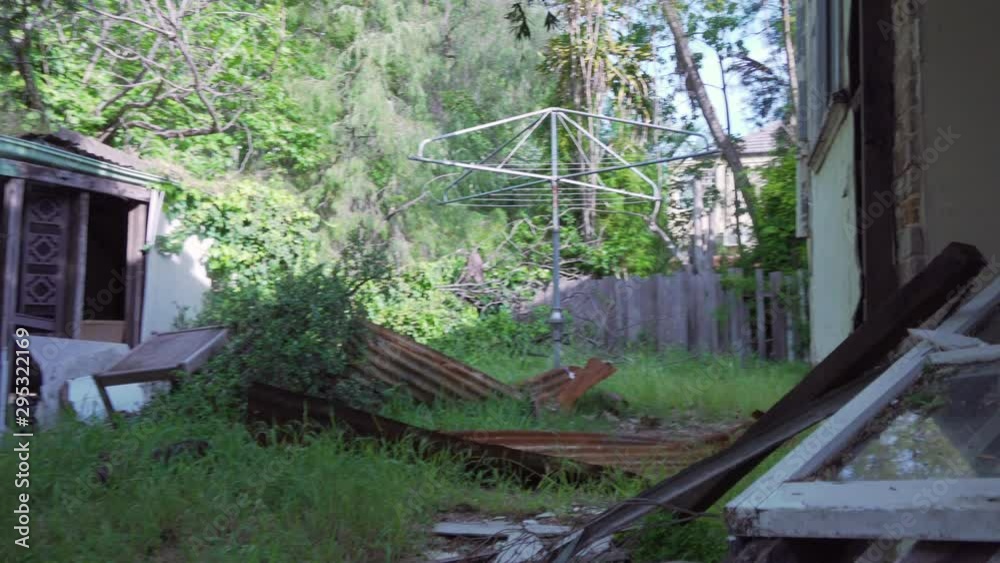 Sweep from side of abandoned, derelict house with cracked render to ...
