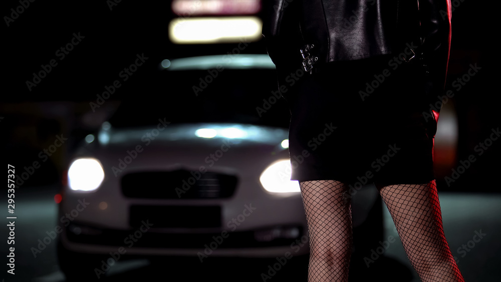 Car driving to prostitute in provocative clothing on dark street, night ...