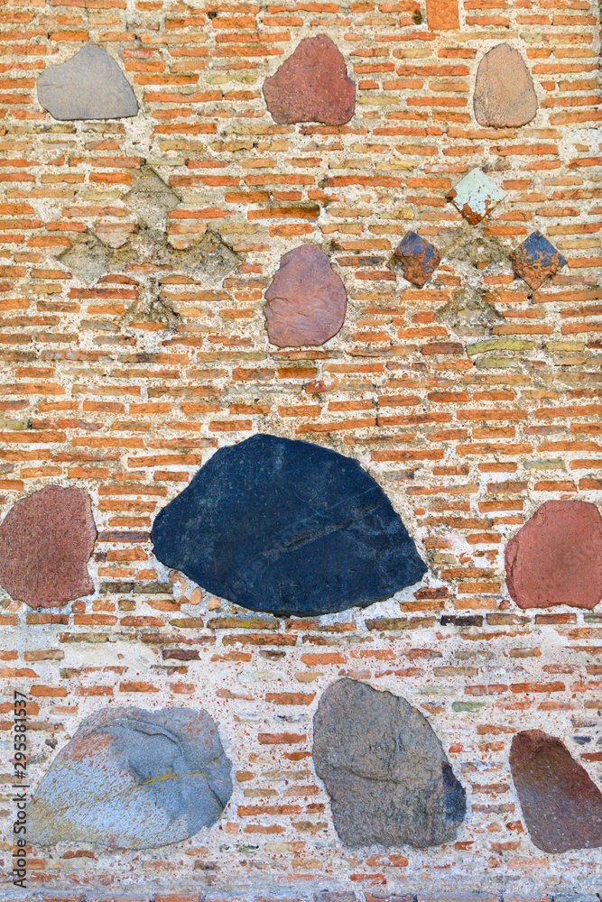 Texture of the old walls of clay brick, decorated with inserts of ...