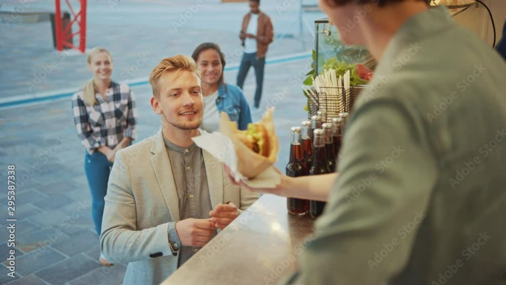 Food Truck Employee Hands Out a Freshly Made Burger to Happy Young Man ...