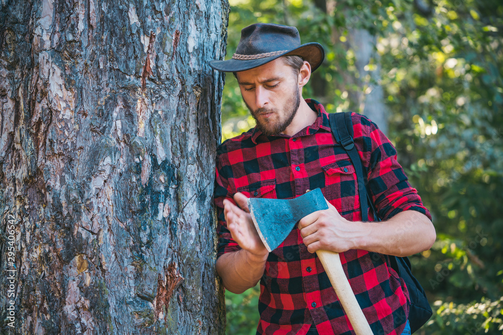 Lumberjack worker walking in the forest with axe. Deforestation is a ...