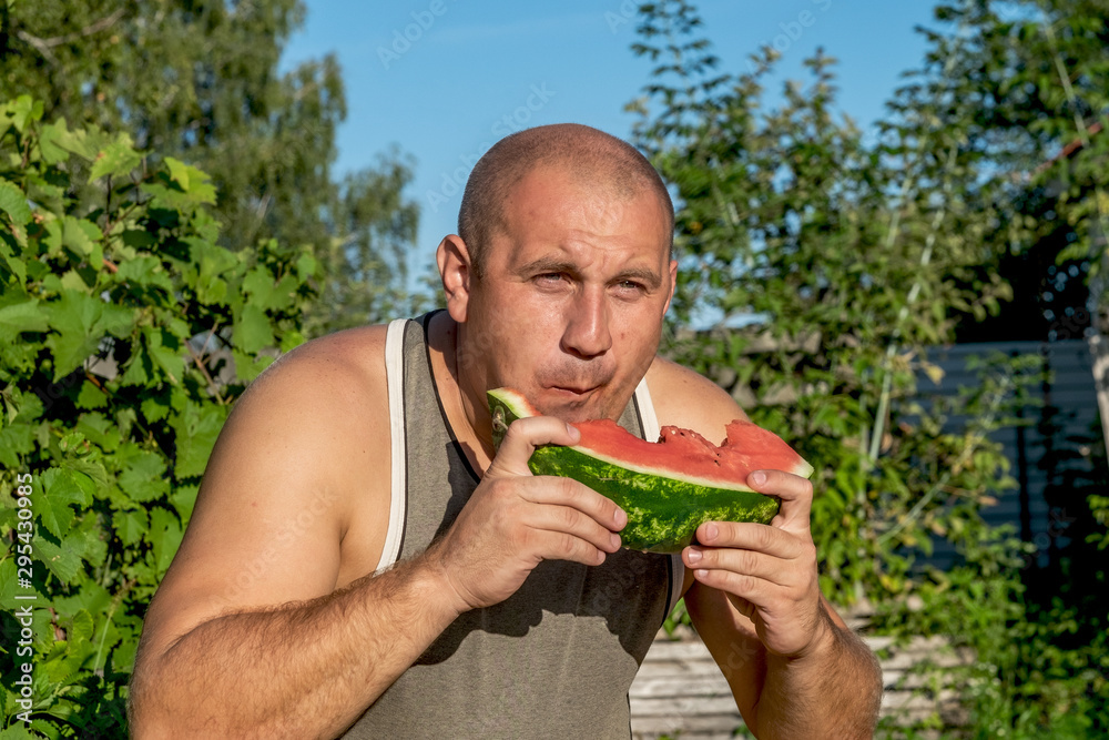 Brutal man enjoying sweet red watermelon. 35-years old male model ...