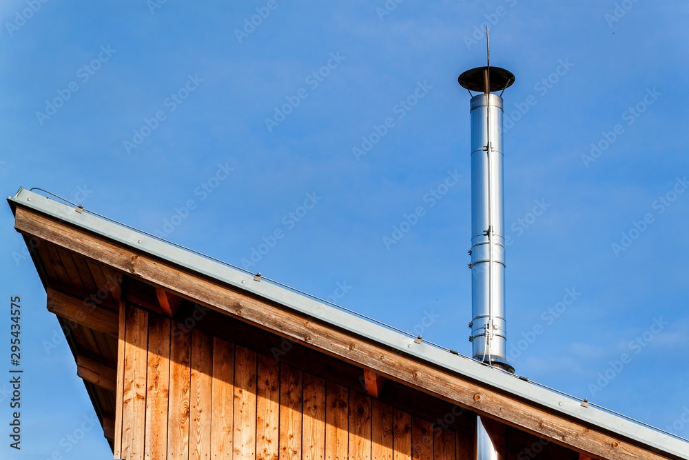 New metal chimney pipe on wooden house. Stainless steel chimney on ...
