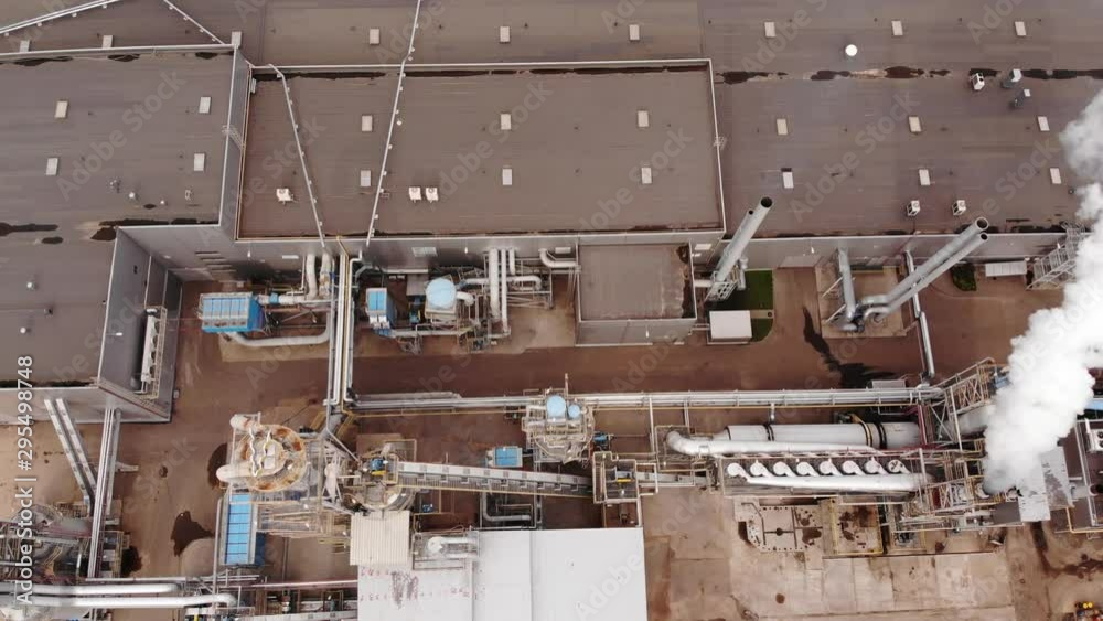 Wood processing plant pollutes the air with smoke coming from the pipe ...