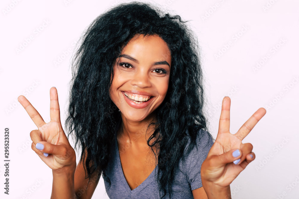 Peace! Full-face portrait of overjoyed African ethnic woman with almond ...
