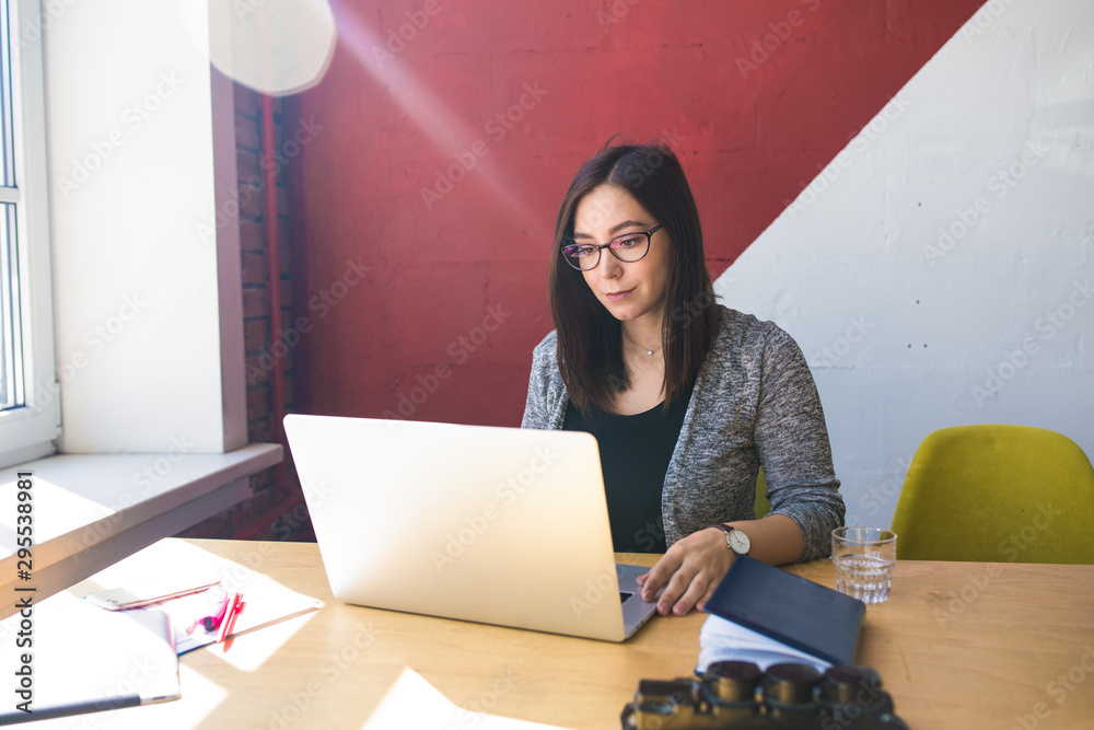 Female freelance social media content writer watching video on web page ...