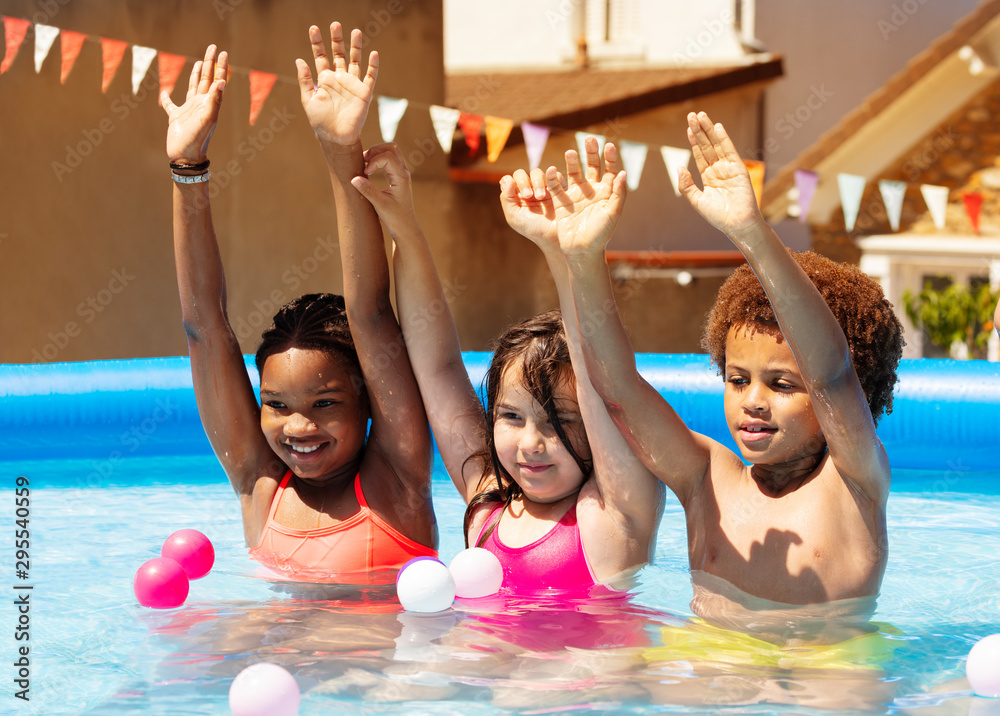 Happy kids lift hands playing in swimming pool Stock Photo | Adobe Stock
